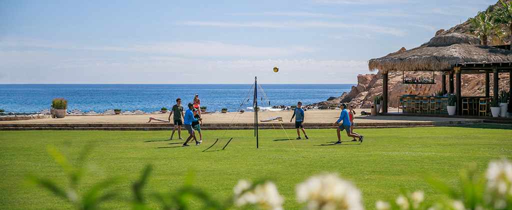 Children playing lawn sports near a three-target net on a grassy field ...